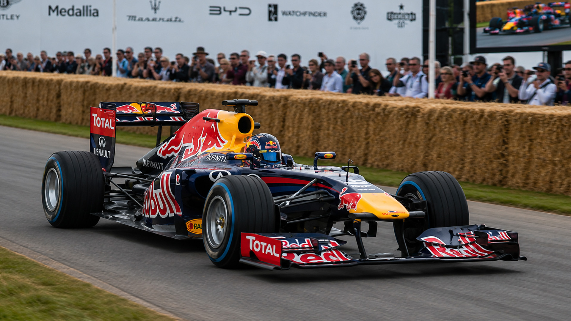 Red Bull RB7 speeds through the crowd at Goodwood