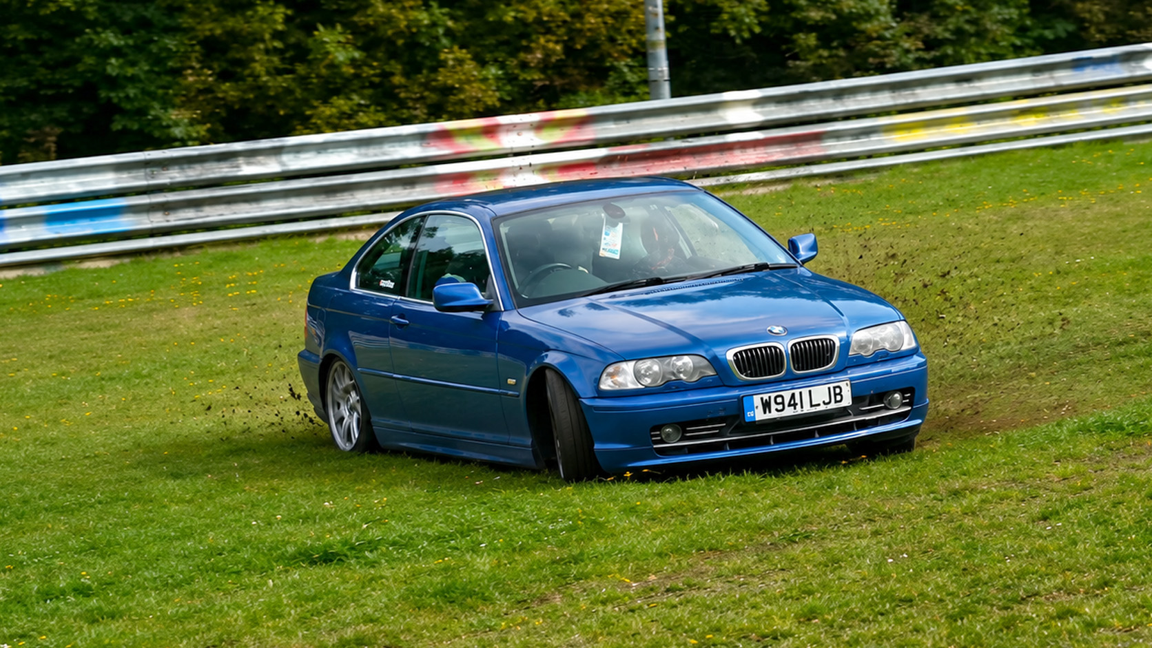 BMW goes out of control and flies off track, creating a close call