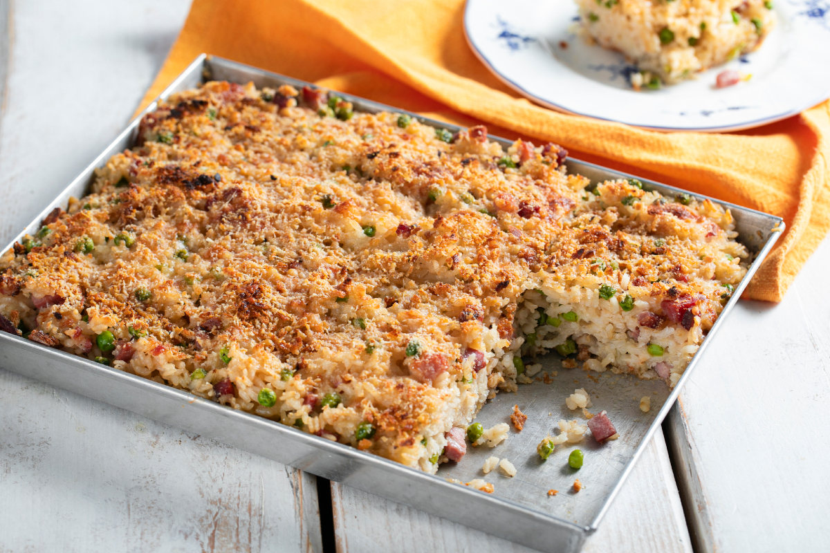 Cheesy baked rice with peas and speck