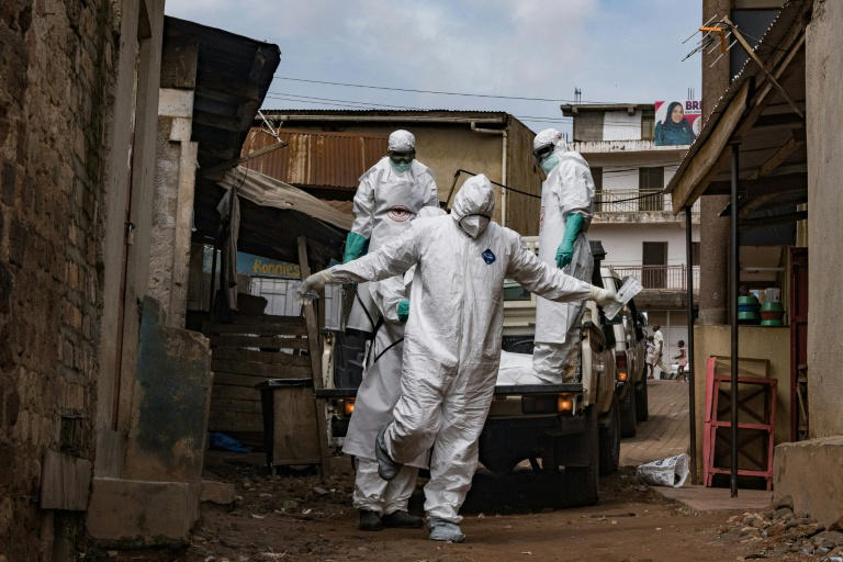 Health workers conduct burials in full protective gear in Ebola ...