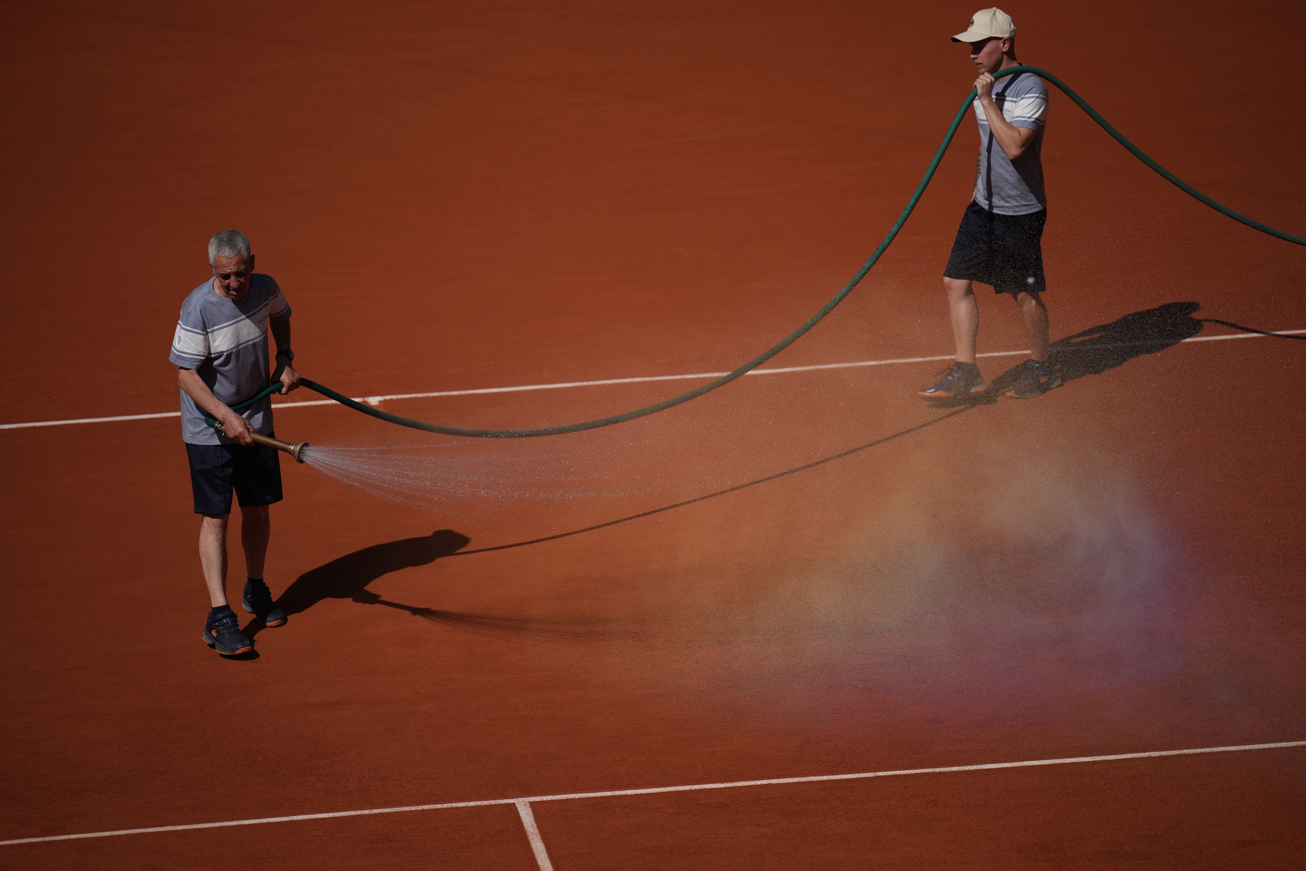 French Open groundskeepers drench the clay courts with water and salt ...
