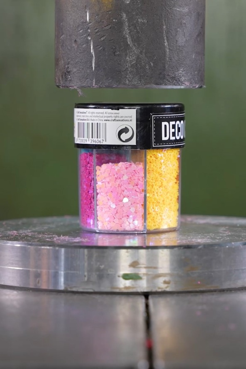 Crushing glitter flakes under hydraulic press