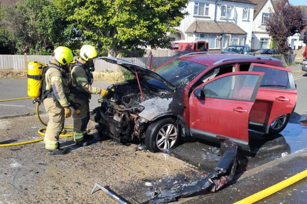 Firefighters at the scene of a car that set alight in Sussex