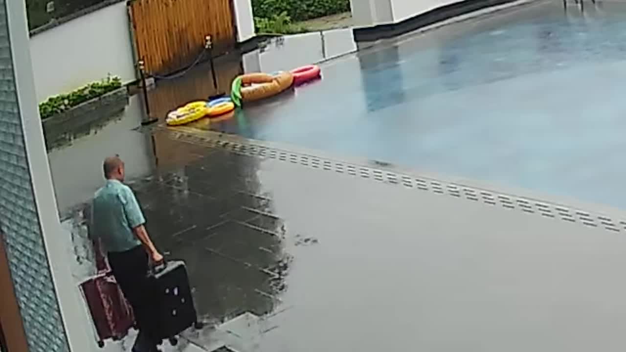 Hotel porter walks straight into swimming pool when he misjudges surface