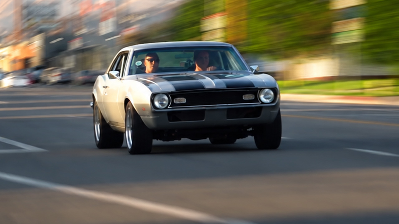 Old '68 Camaro roars through a raw street drive