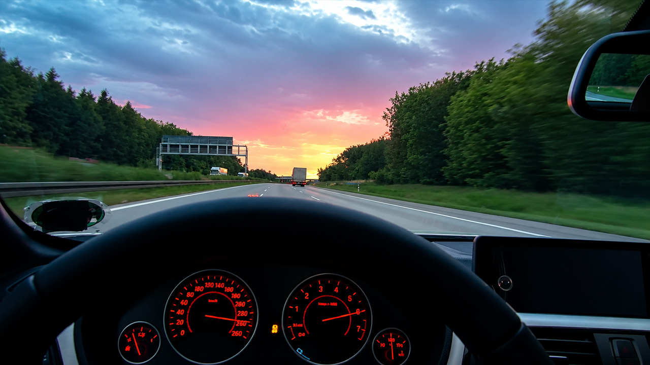BMW 435i accelerates into an autobahn sunset
