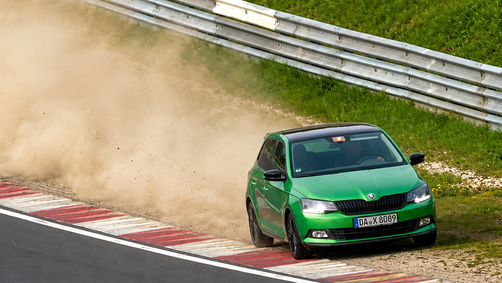 Hatchback-Fahrer fährt hart nah an die Barriere und wirbelt viel Staub auf