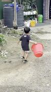 Kid spins with bucket on head before falling