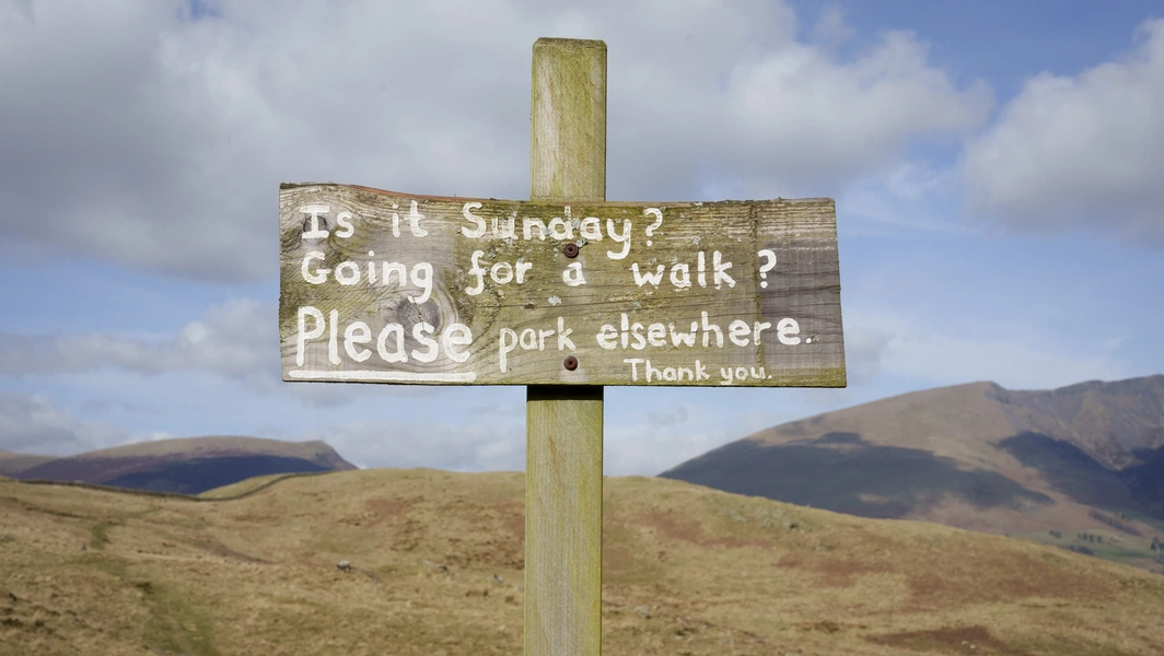 Farmer sprays slurry on cars parked on Lake District field