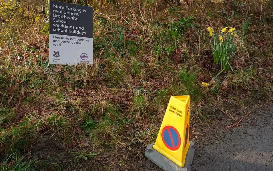 Farmer sprays slurry on cars parked on Lake District field