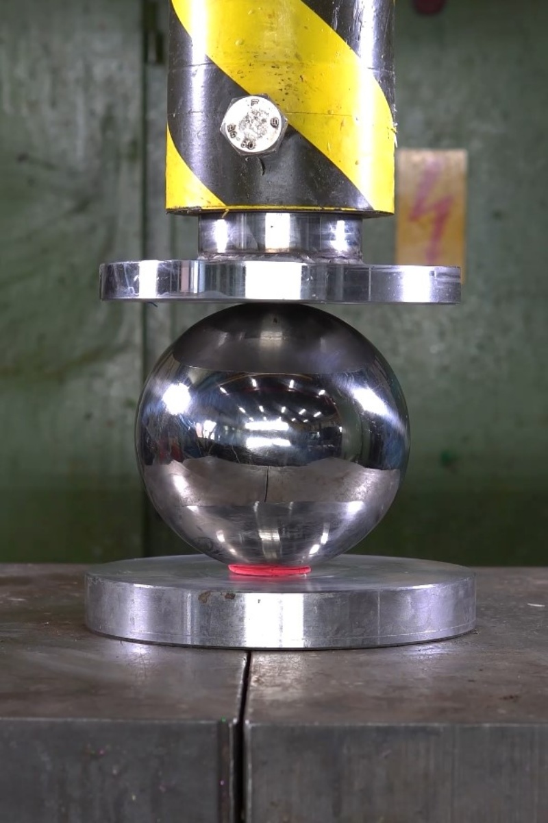 Crushing a metal sphere under hydraulic press