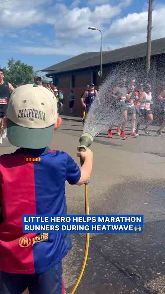 Young boy cools down marathon runners with hose during heatwave