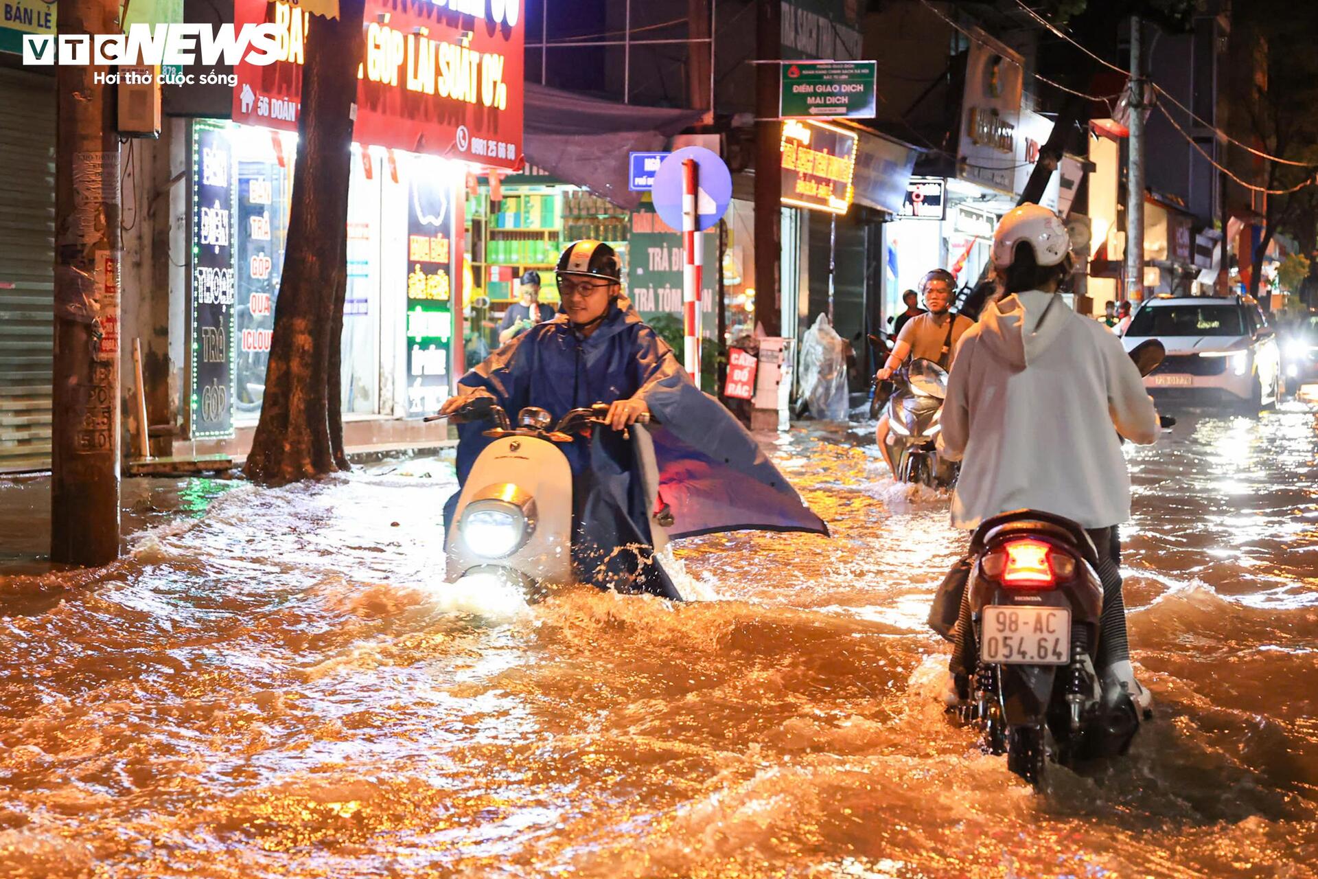 Tối muộn, dân Hà Nội vẫn vật vã dắt xe lội nước về nhà sau cơn mưa giải ...