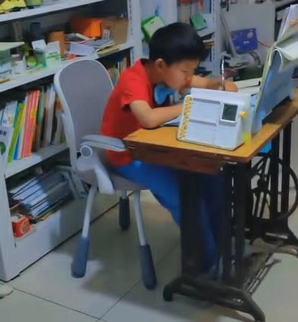 Chinese student does homework while pedaling sewing machine for focus