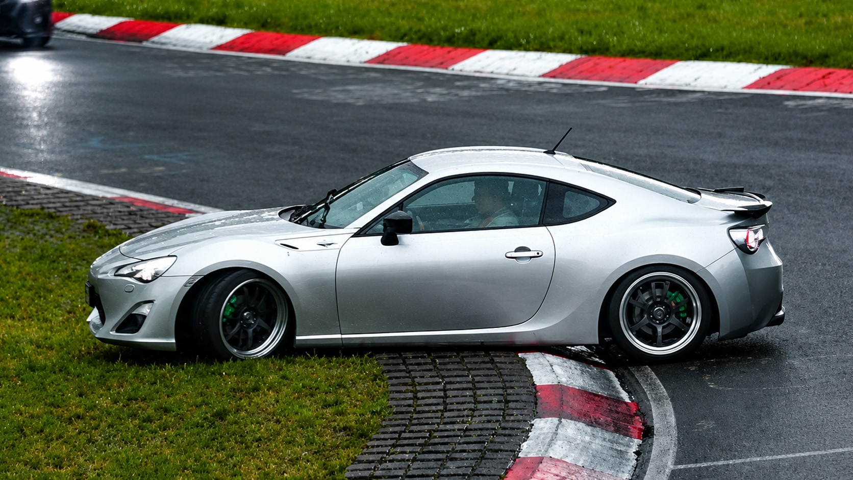 Sports car loses control mid-corner and hits the separator