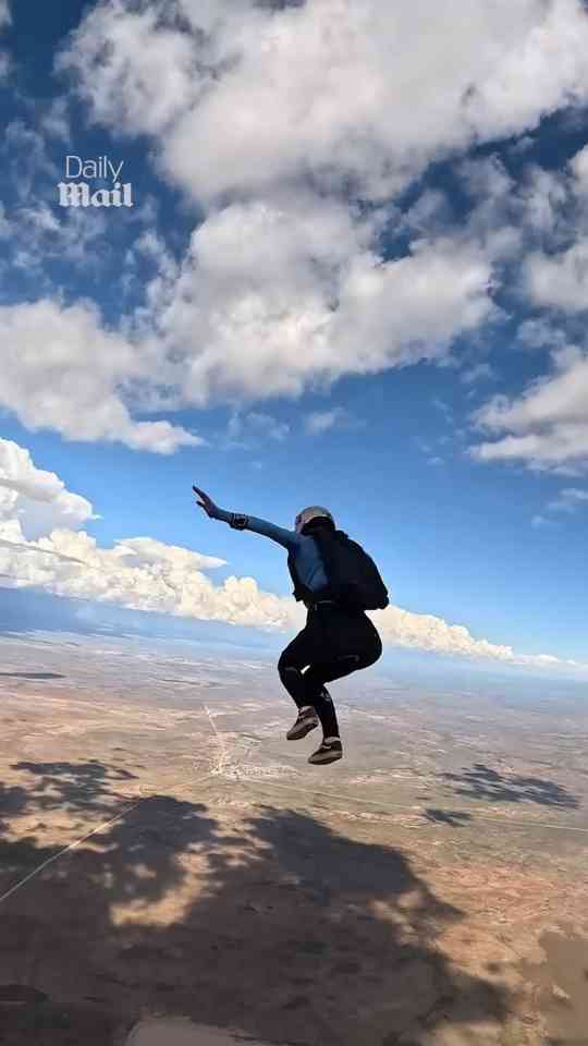 Thrill-seeker skydives beside massive storm clouds