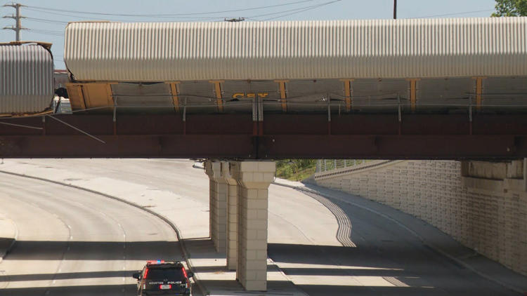 Train cars leaning over overpass in northwest Houston