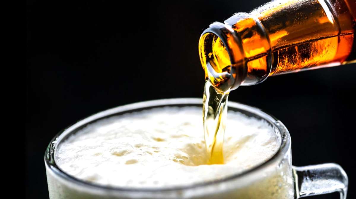 Waarom schuimt bier minder als je het glas schuin houdt?