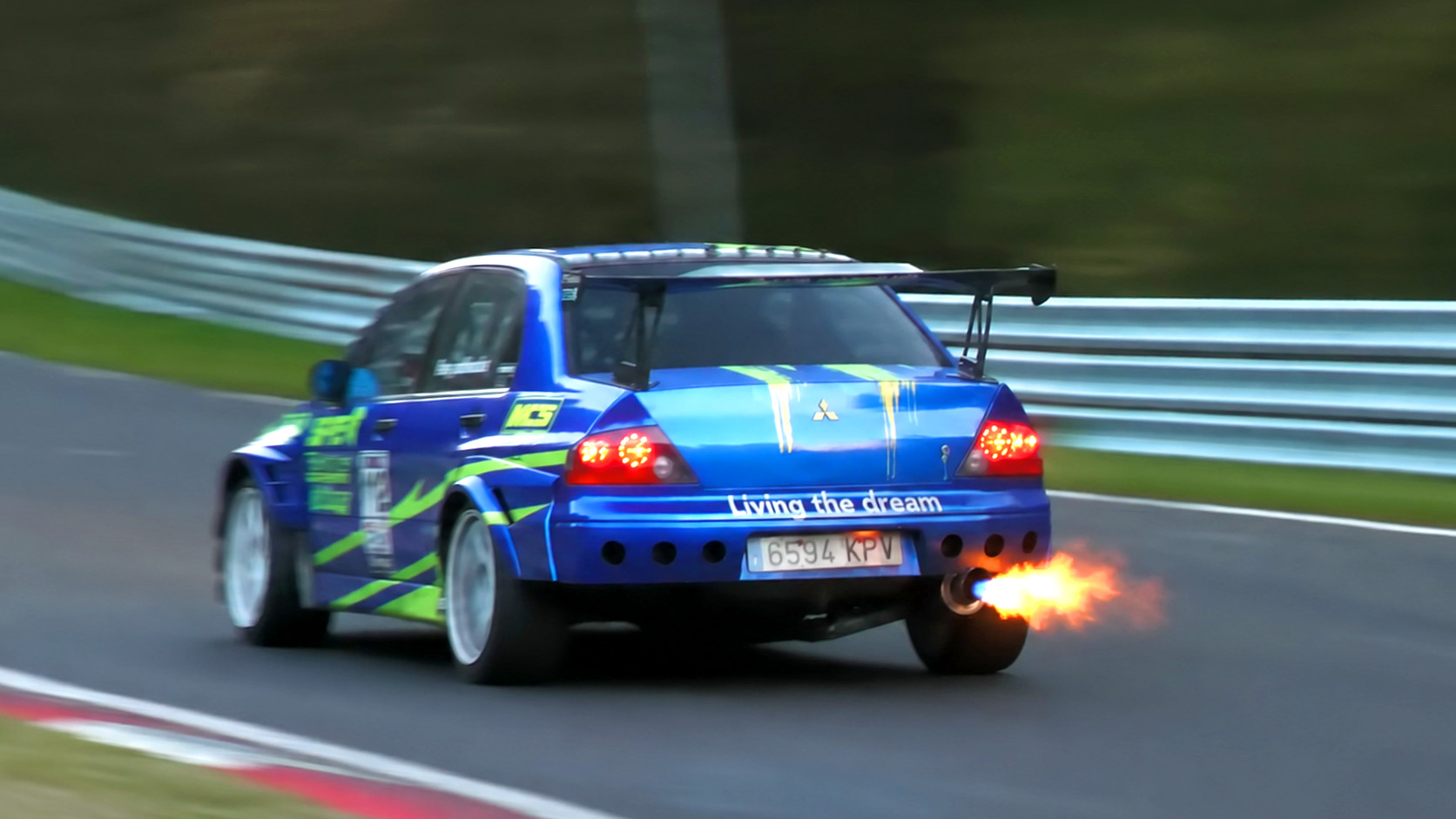 Mitsubishi Evo race car shoots flames during a high-speed track run