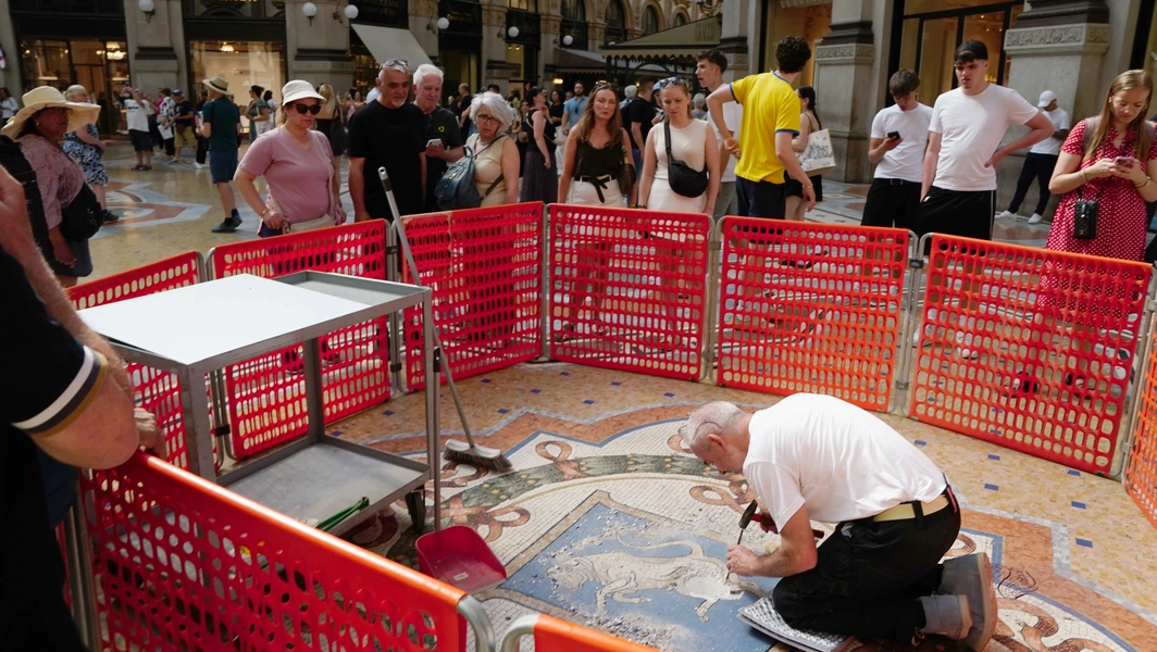 Milan restores bull mosaic worn by tourist ritual