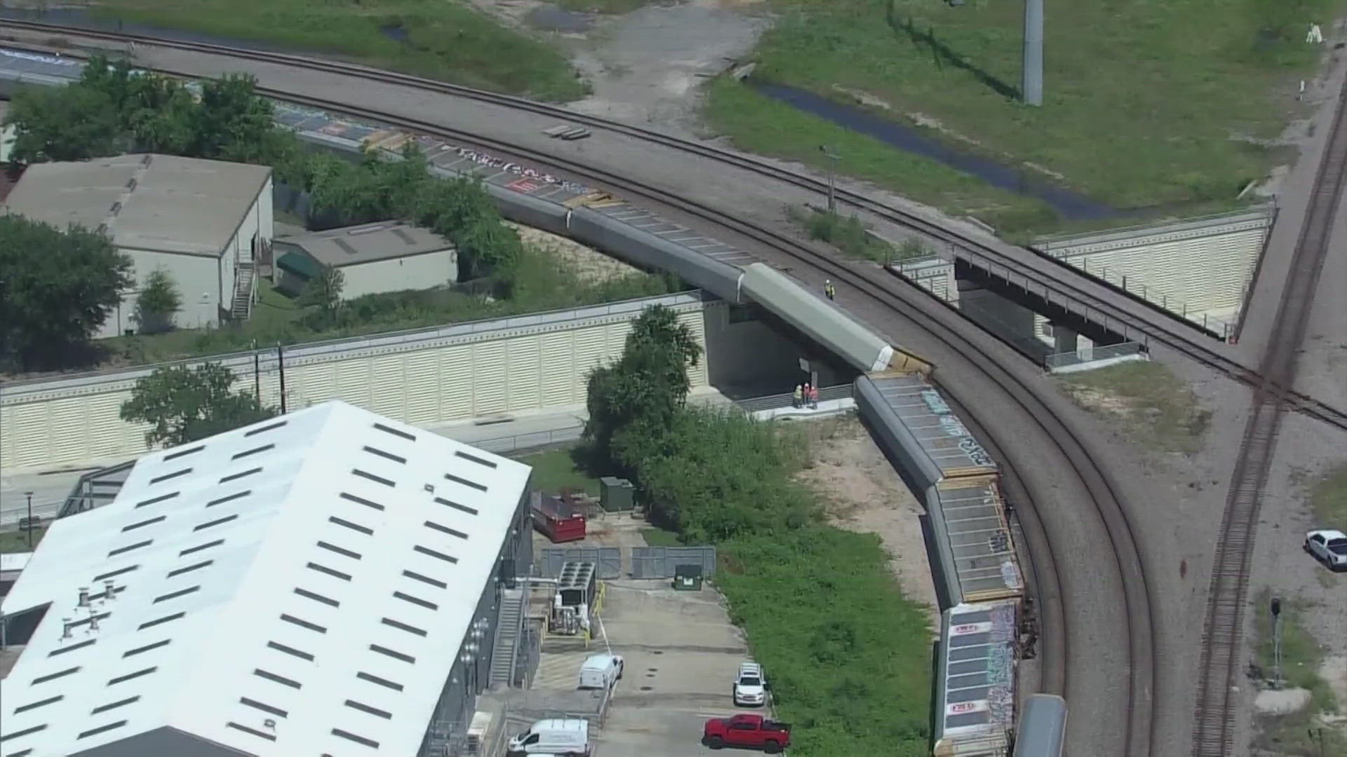 Train cars leaning over overpass in northwest Houston