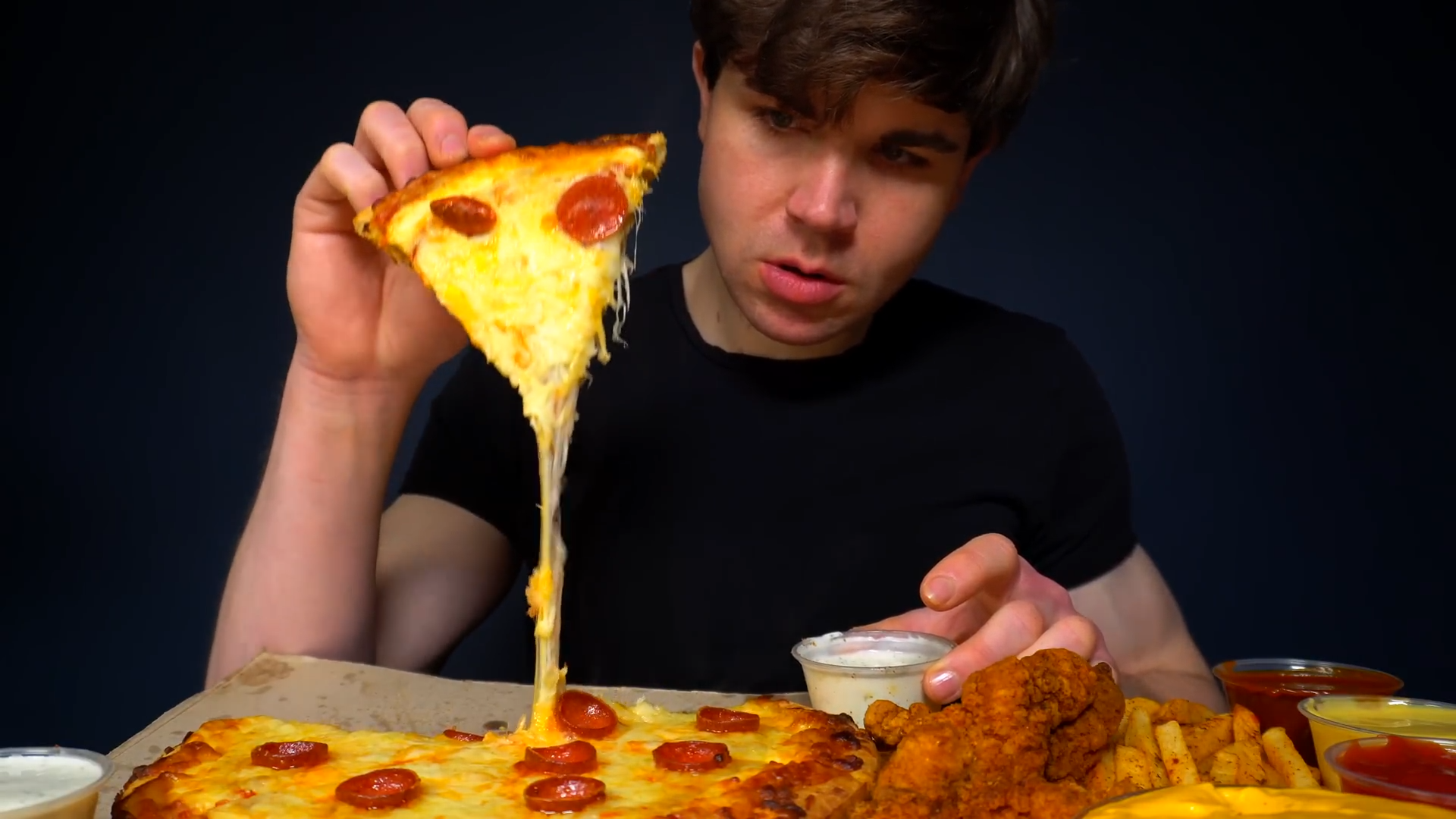 Man eats enormous & extra cheesy pizza