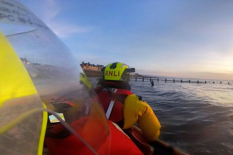 Trapped woman on Rhyl beach up to waist in water with tide rushing in
