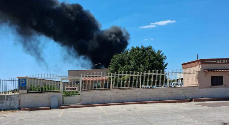 Incendio in un capannone, colonna di fumo nero