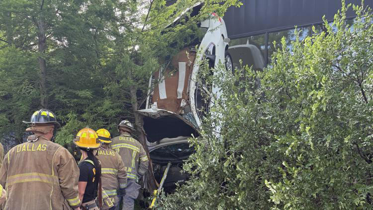 Dallas firefighters rescue driver after car crashes vertically between ...