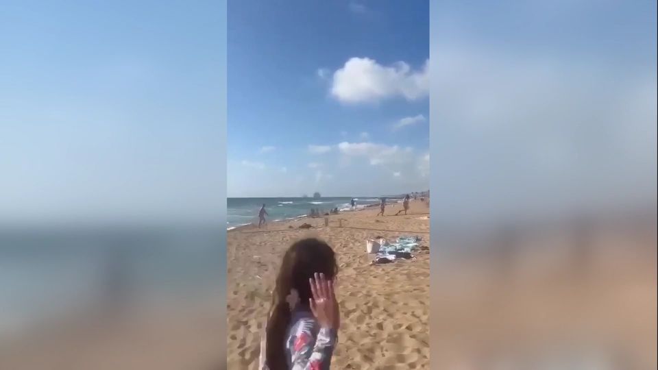 Beachgoers flee as projectiles fall into the sea in Israel