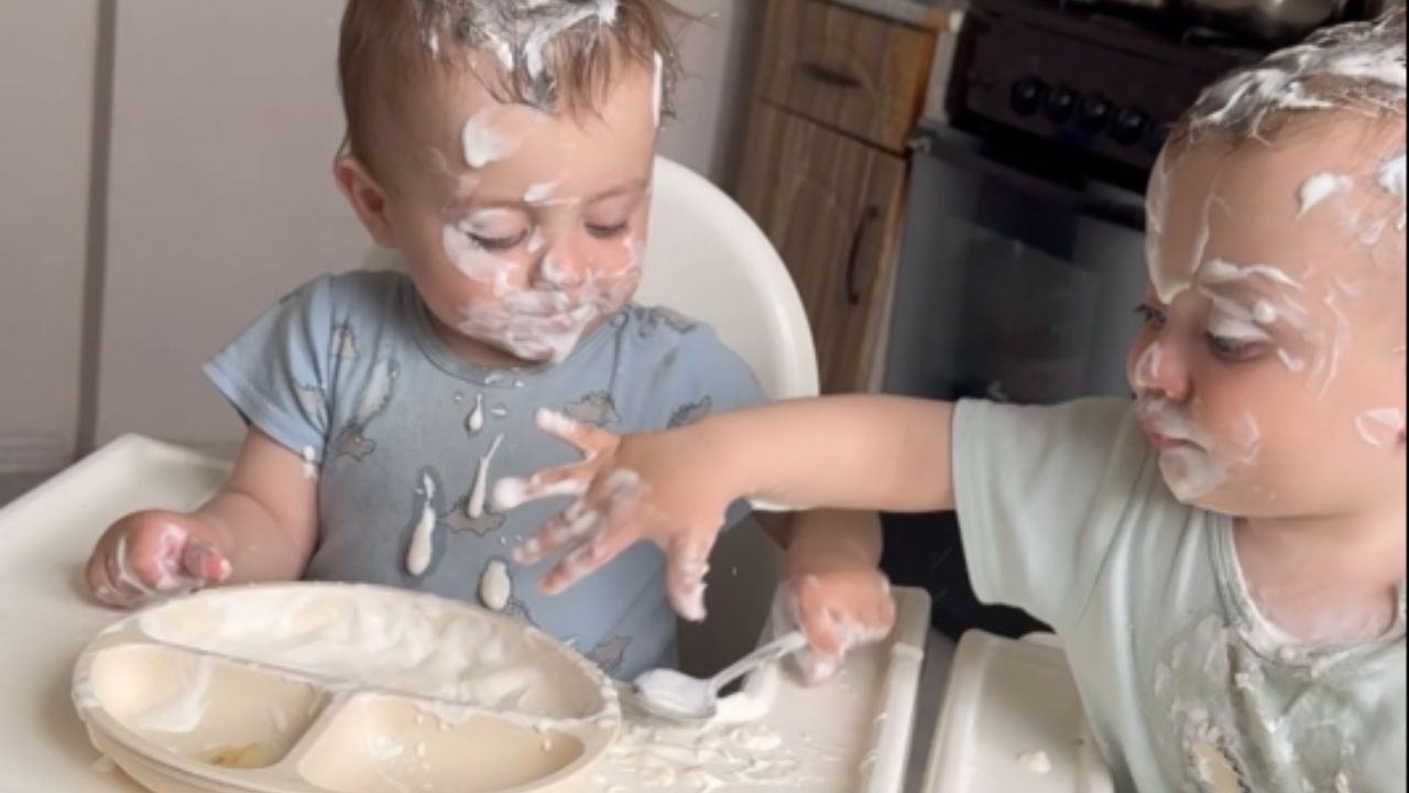 Twins get yogurt on their faces, hands, and hair while eating