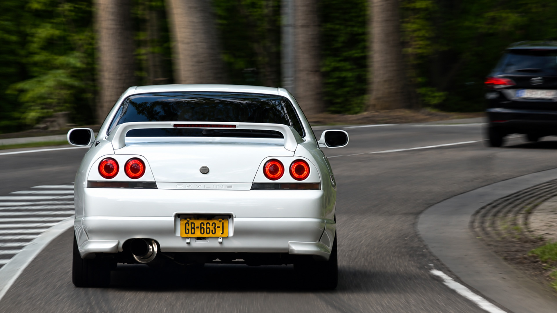 Skyline R33 fährt zügig auf einer öffentlichen Straße