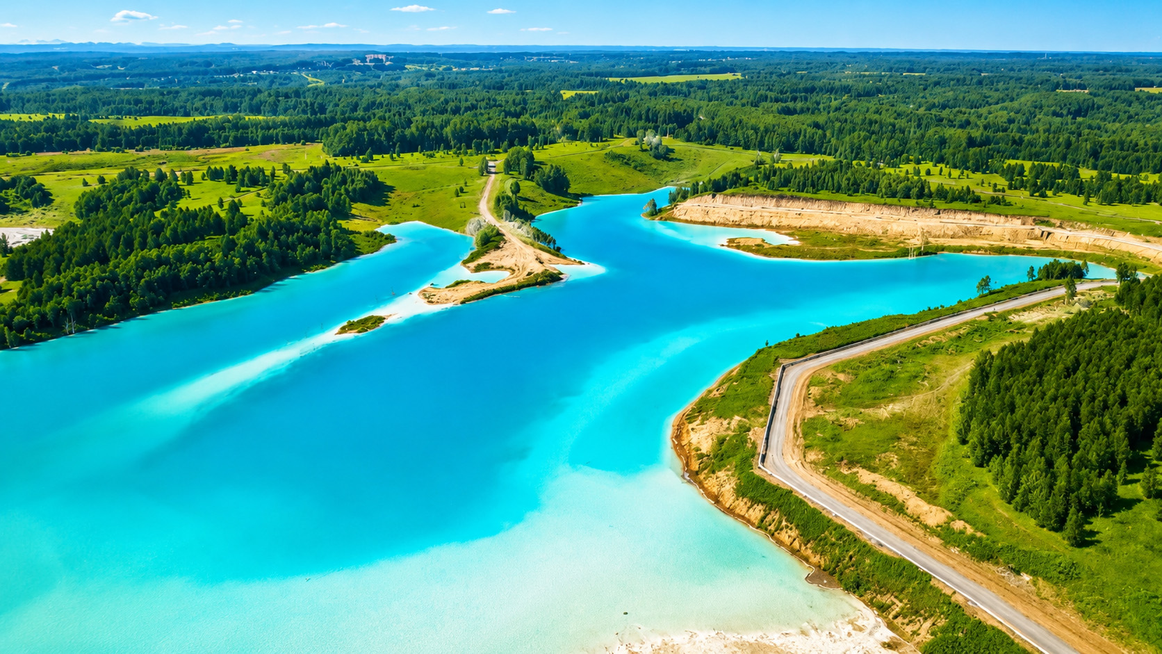 A turquoise lake winding through an endless green valley