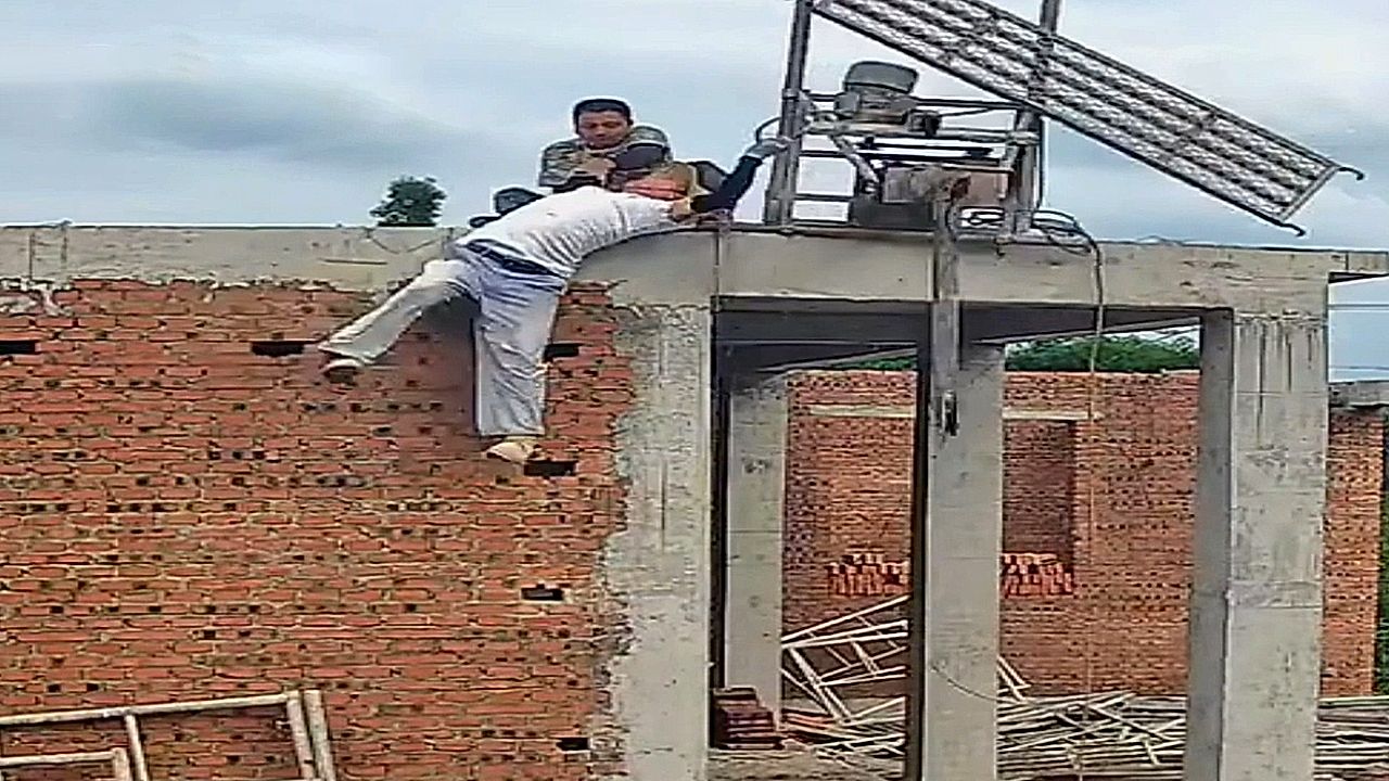 Coworker catches man sent falling off roof as hoist tips over edge in China