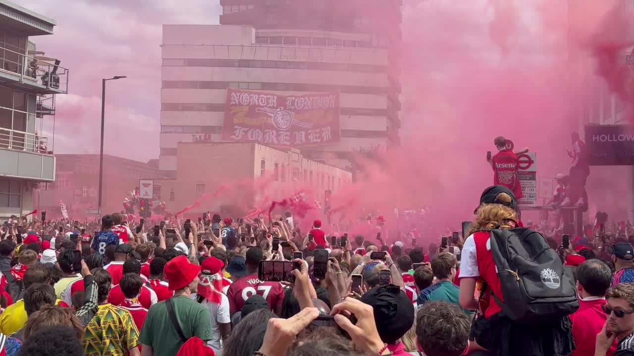 Arsenal parade passes through a thick wall of red smoke as thousands of ...