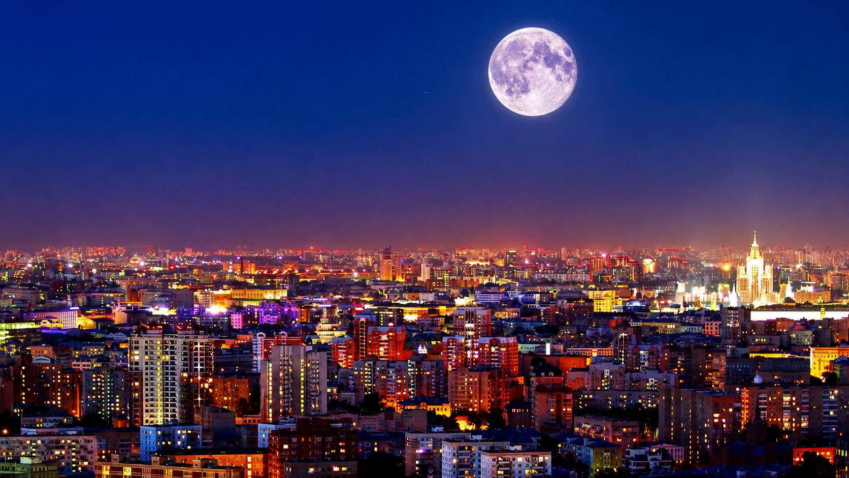 Een enorme volle maan boven de stads skyline