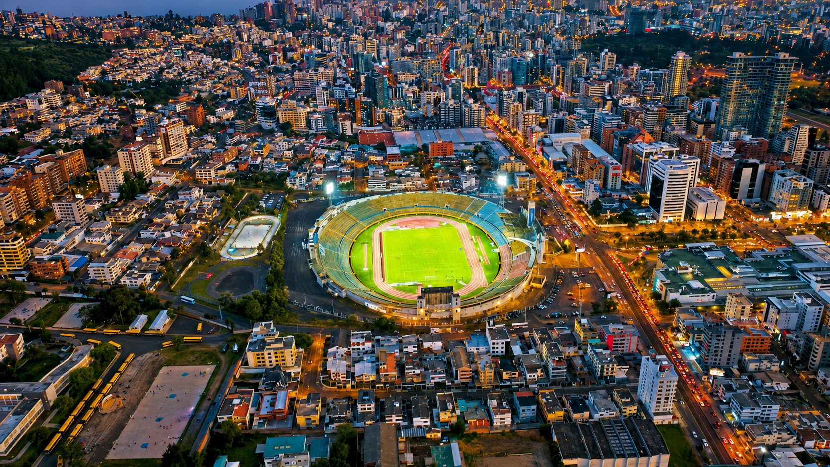 A glowing stadium lighting up the city center at night