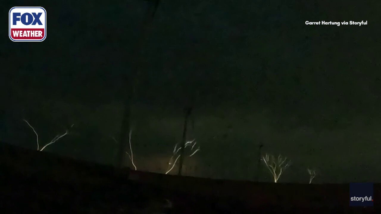 Upward lightning shoots into sky from wind turbines