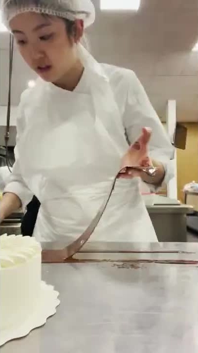 Decorating a black forest cake in pastry school