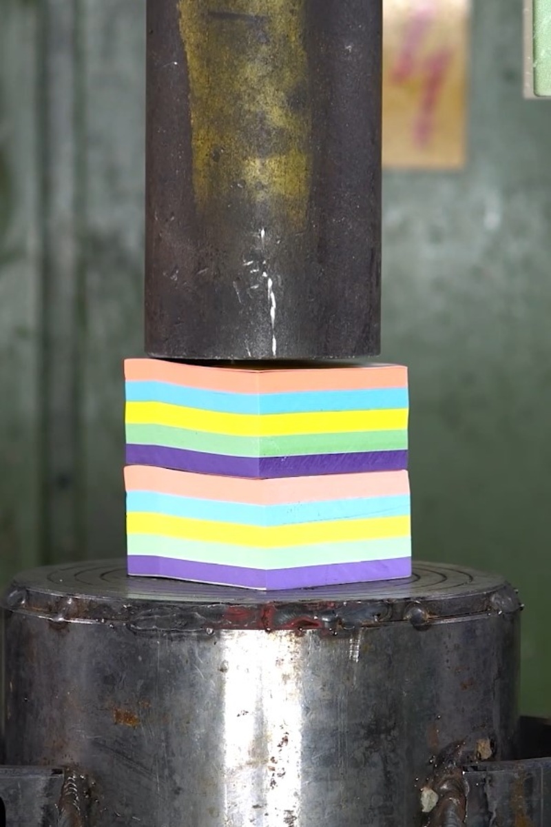 Crushing a colorful layered block with hydraulic press