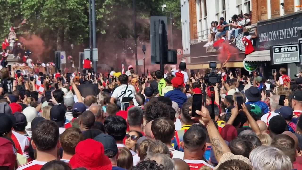 Smoke flares turn north London red during Arsenal trophy parade