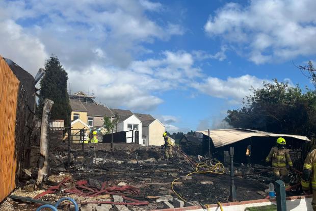 Huge fire forces evacuations as flames spread between homes and buildings