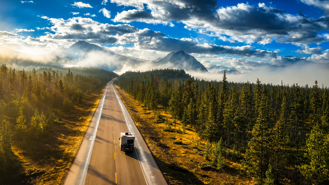 Scenic road trip through a mountain forest wrapped in morning mist