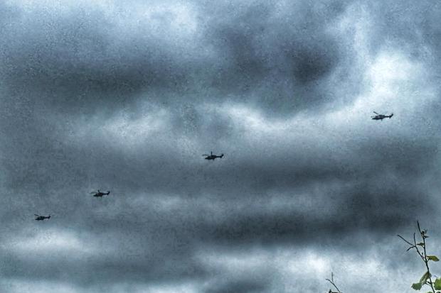 Four military helicopter fly over the county in formation