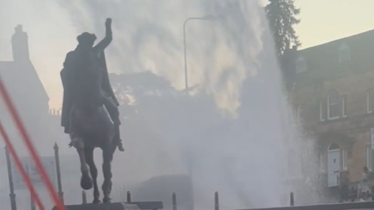 Water rushes from a broken pipe near the Fine Lady statue