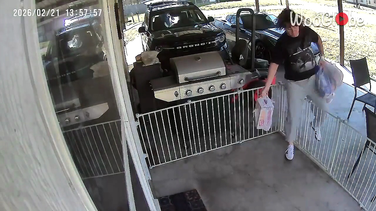 Woman falls forward over gate while holding multiple bags from grocery trip
