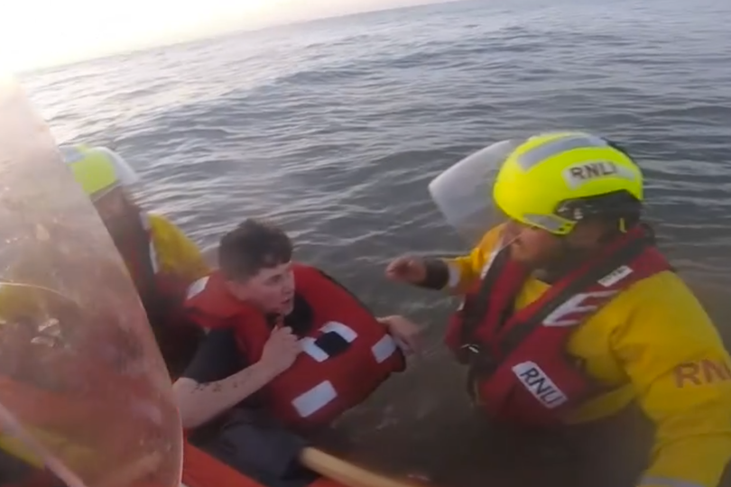 Sinking person stuck in quicksand as tide rises
