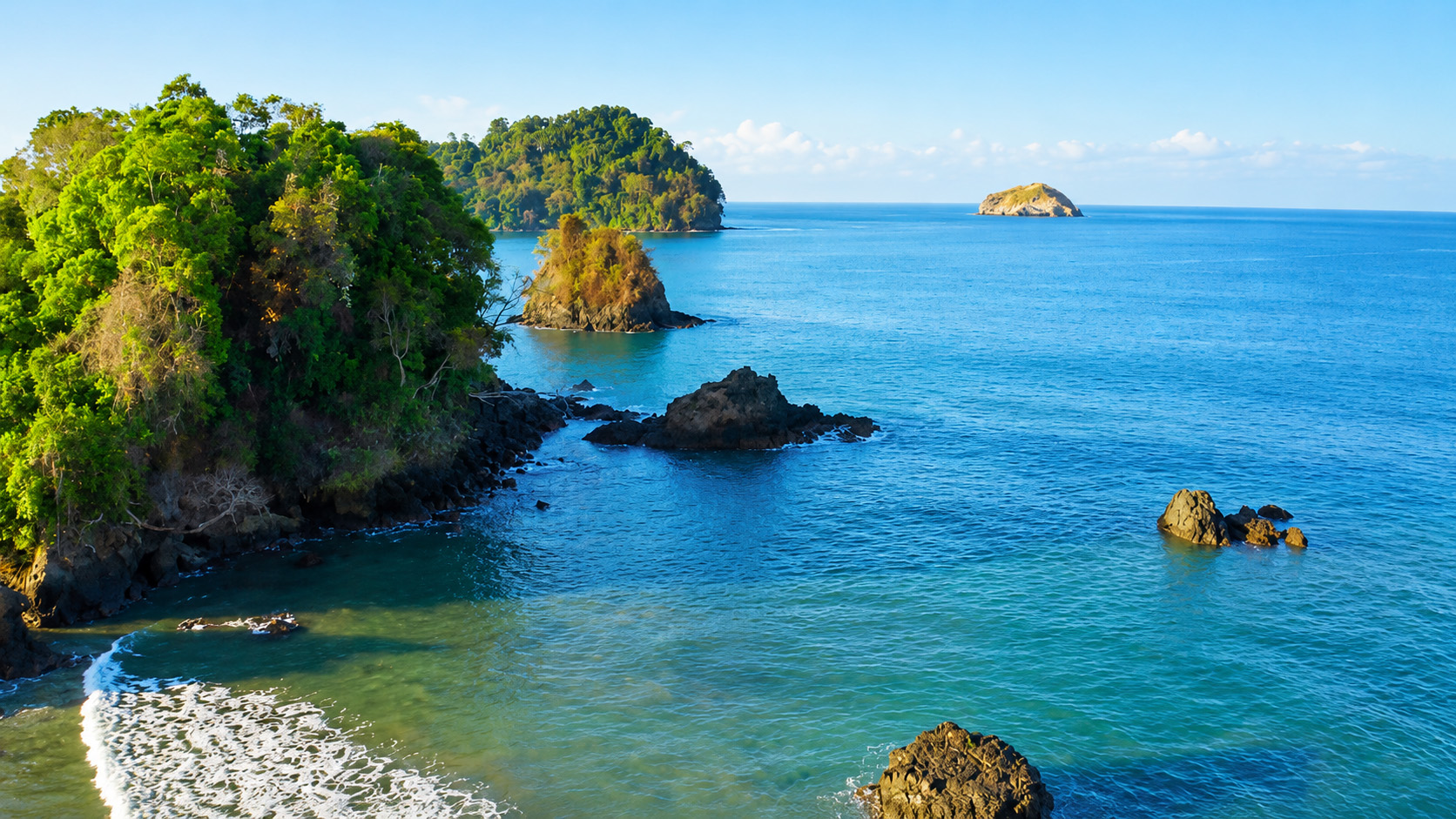 Hidden rocky islands scattered along a tropical blue coastline