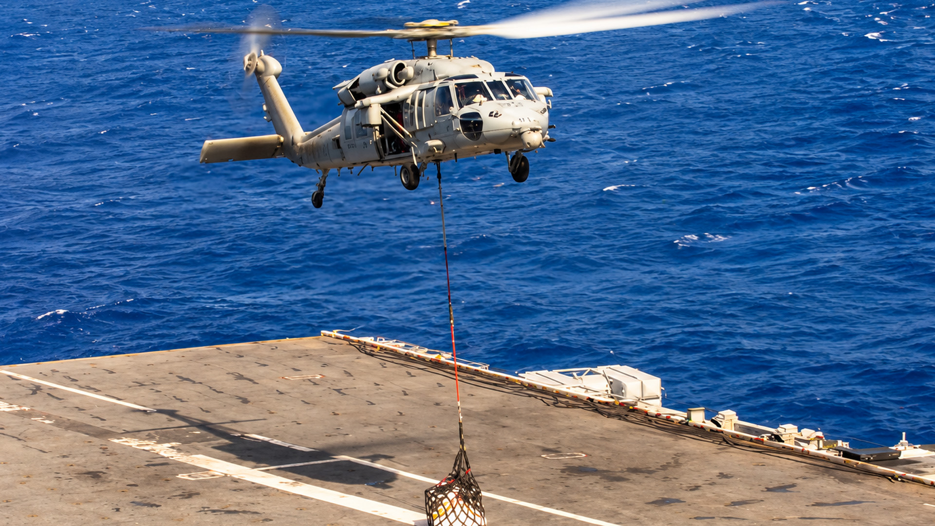 Regardez des hélicoptères ravitailler l'USS Nimitz en mer