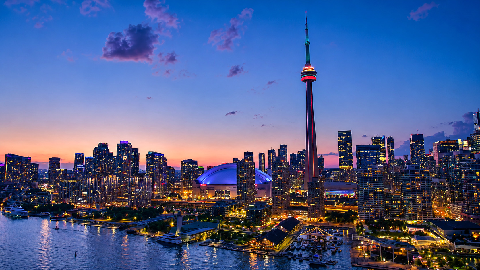 Toronto’s CN Tower rising above a golden sunset skyline